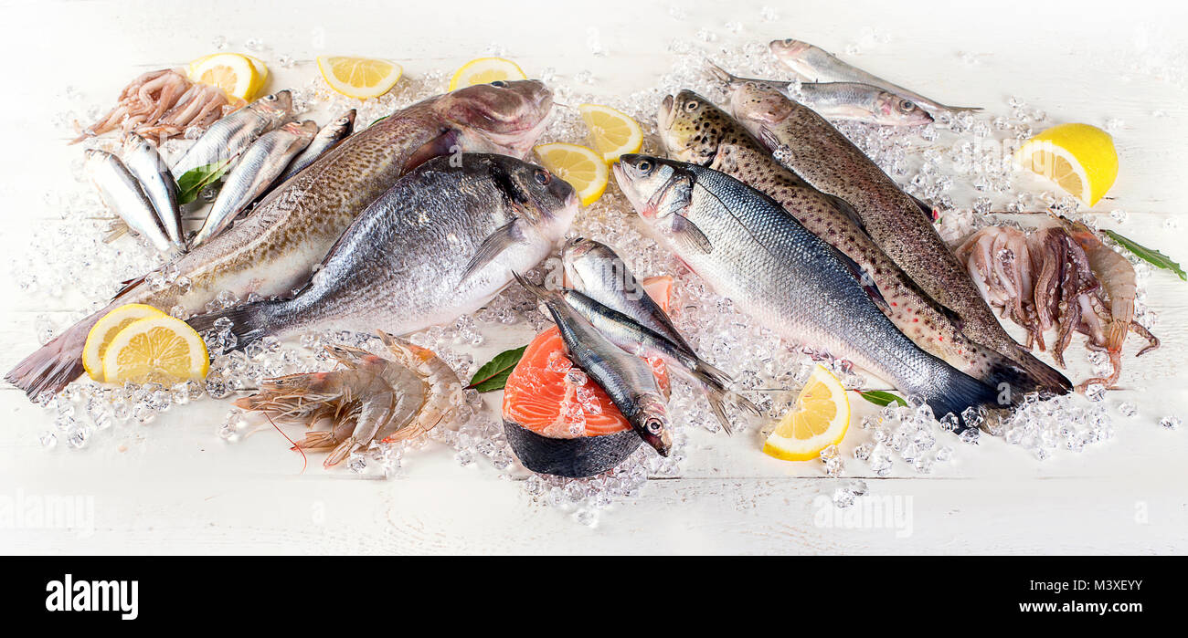 Fresh fish and seafood on white wooden background. Healthy eating. Top ...