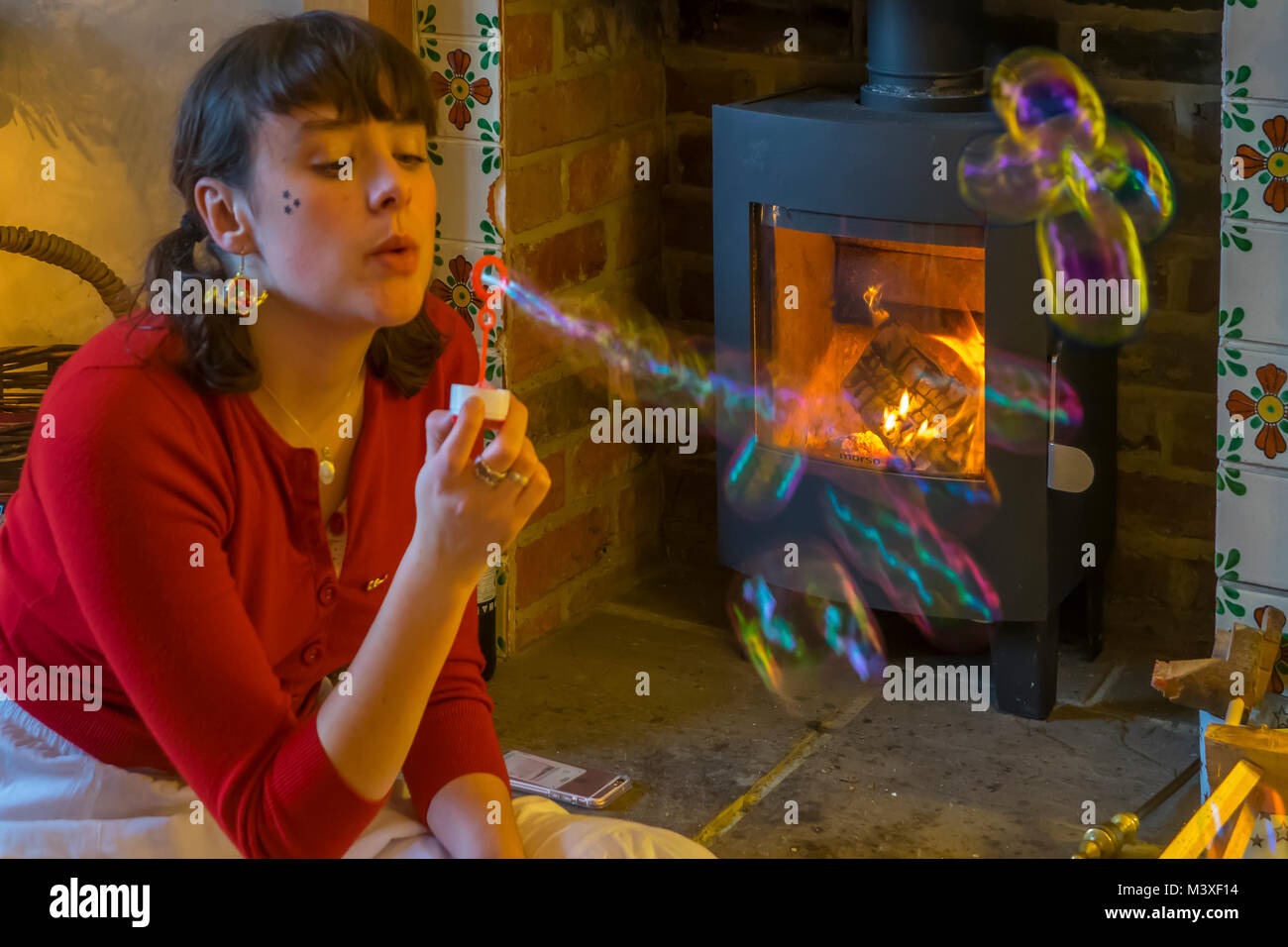 Girl blowing bubbles in front of fire Stock Photo - Alamy