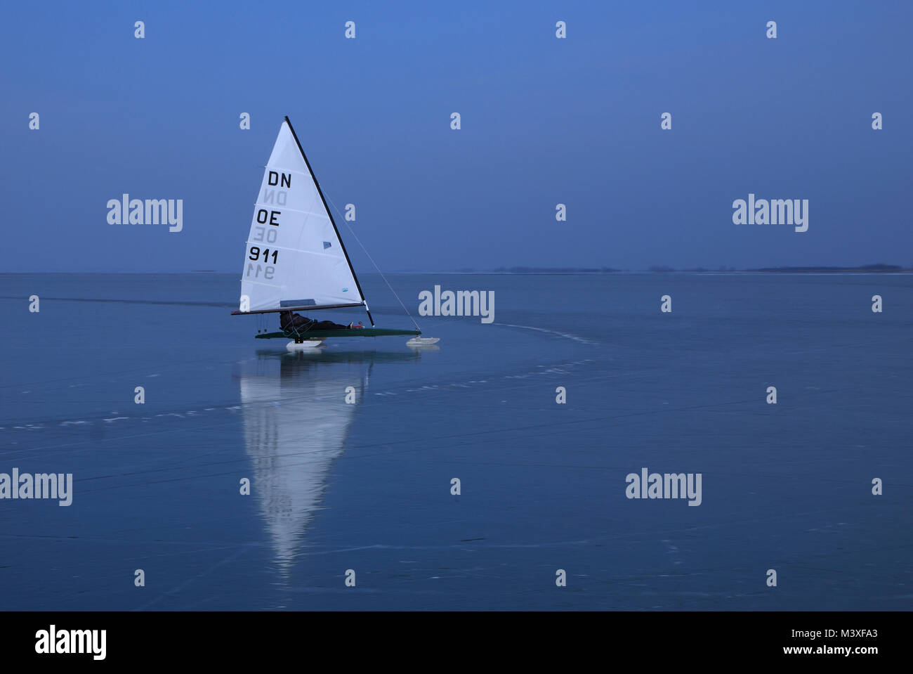 individual ice boaters on glassy frozen lake in winter view on the left ...