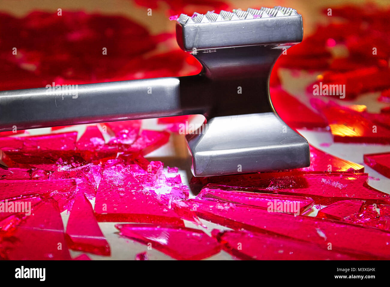 Closeup of cracking broken glass candy with a mallet Stock Photo - Alamy