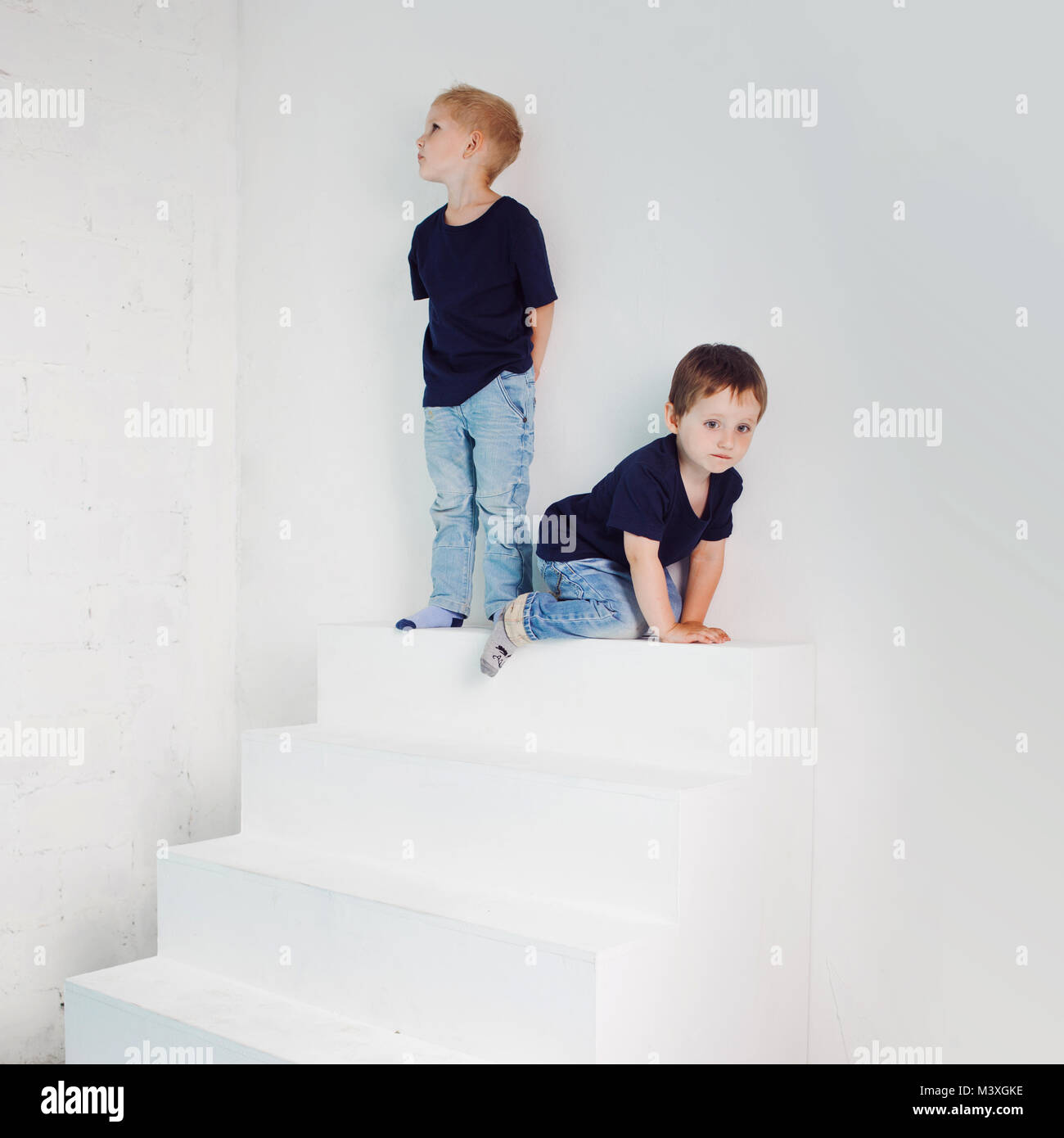 Two boys climb up the stairs. Senior and the younger brother. The ...