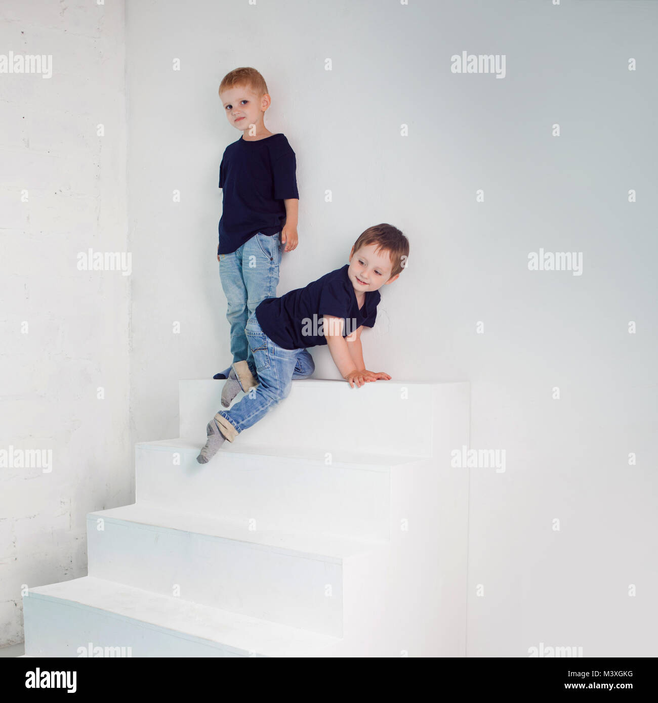 Two boys climb up the stairs. Senior and the younger brother. The ...