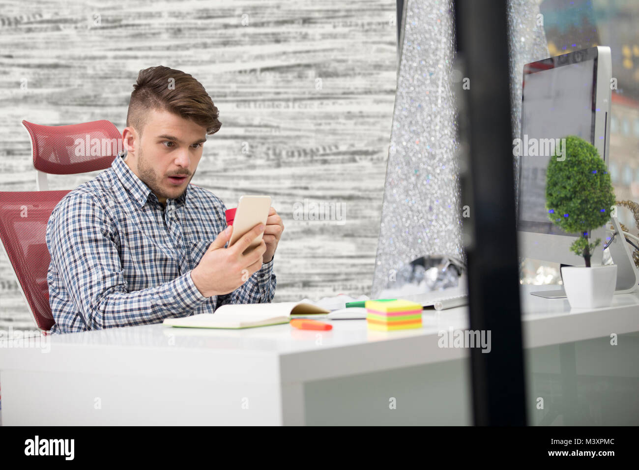 Young happy businessman smiling while reading his smartphone Stock ...