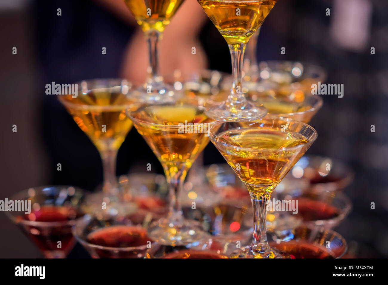 Pyramid of glasses with golden and red beverages, vine, wine, champagne ...