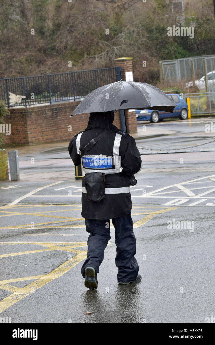 A traffic warden or civil enforcement office in a rain storm or ...