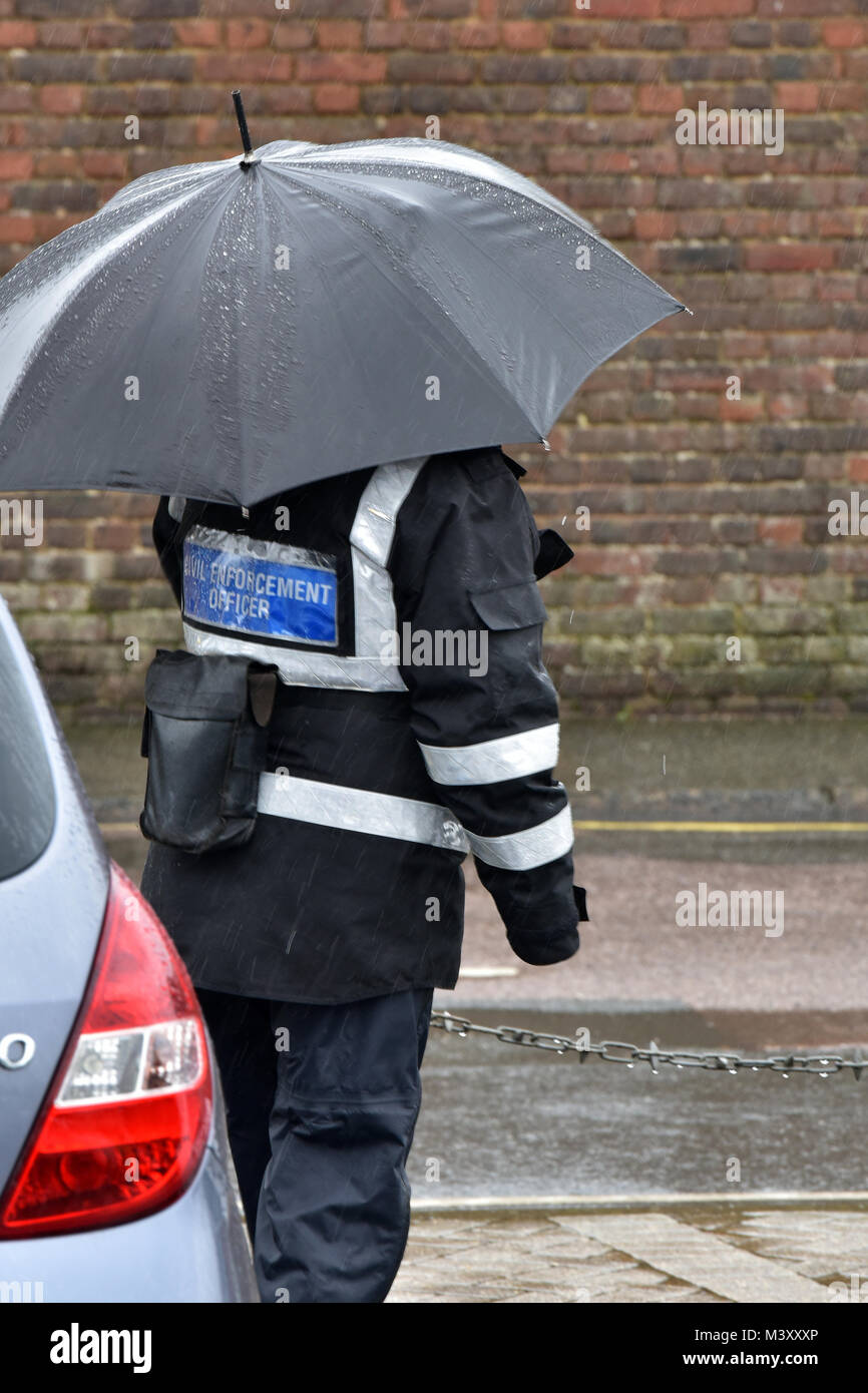A traffic warden or civil enforcement office in a rain storm or ...