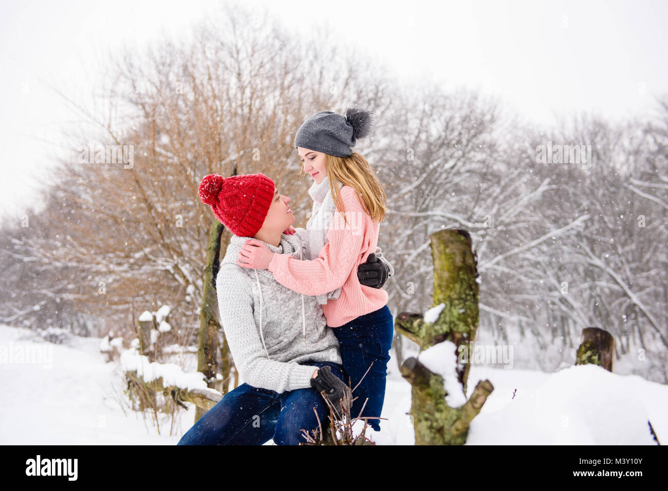 Girl and boy casual looking in hugs at snow forest Stock Photo - Alamy