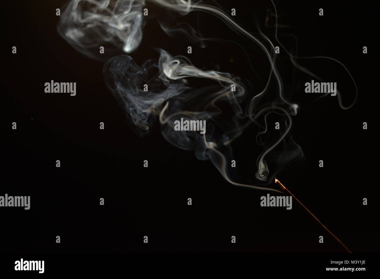 smoldering aromatic stick in the dark, a lot of smoke Stock Photo - Alamy