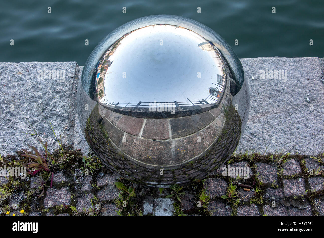 A reflection of a paving stone with a stone wall in a steel ball Stock ...