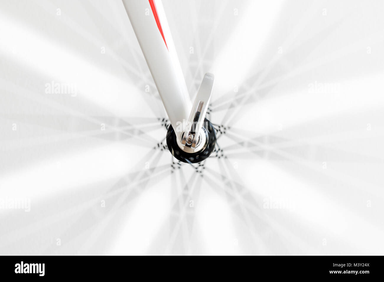 The front wheel of the bicycle rotates quickly on a white background ...