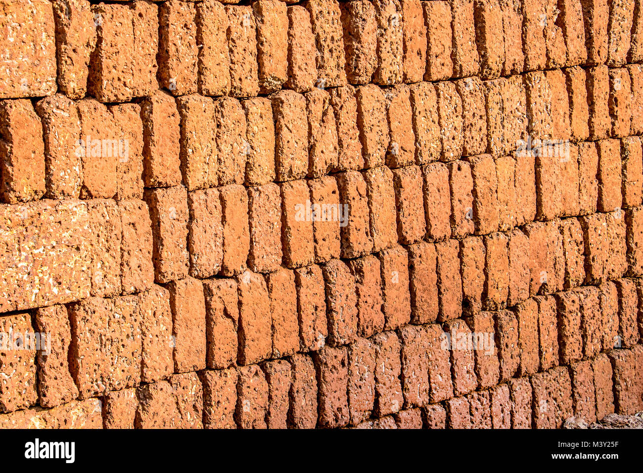 a red bricks folded in a row. Construction material ready for ...