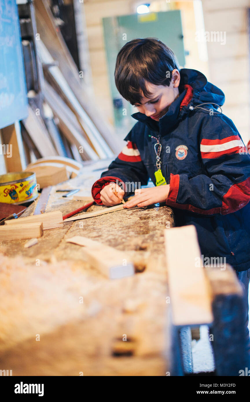10-year-old boy in a carpenter's workshop learns to do small jobs ...