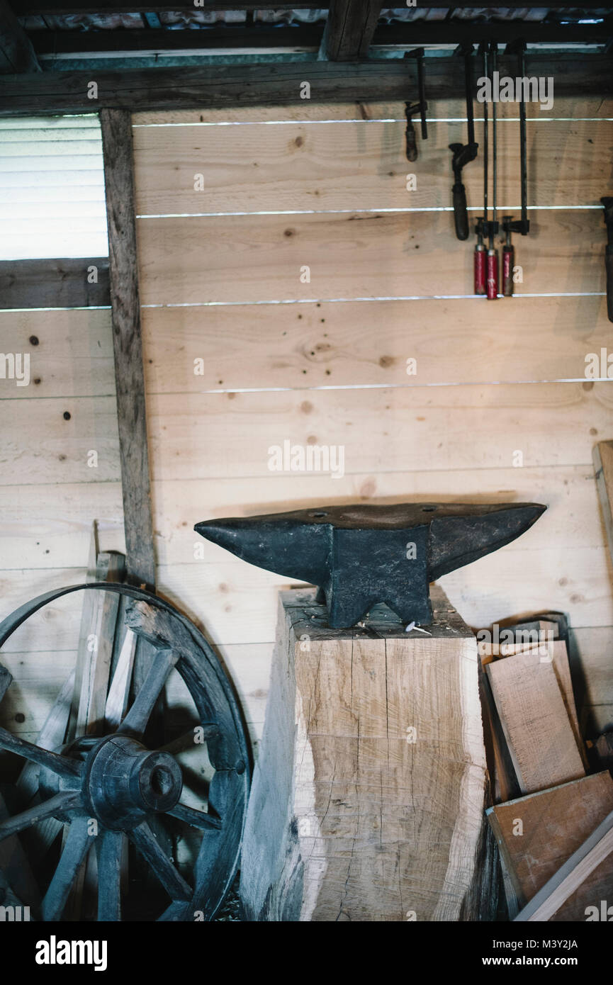 carpentry workshop with anvil and other tools and old wagon wheel Stock ...