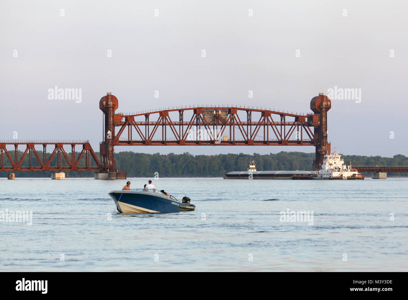 A barge on the Mississippi River passes under the BNSF railroad lift ...