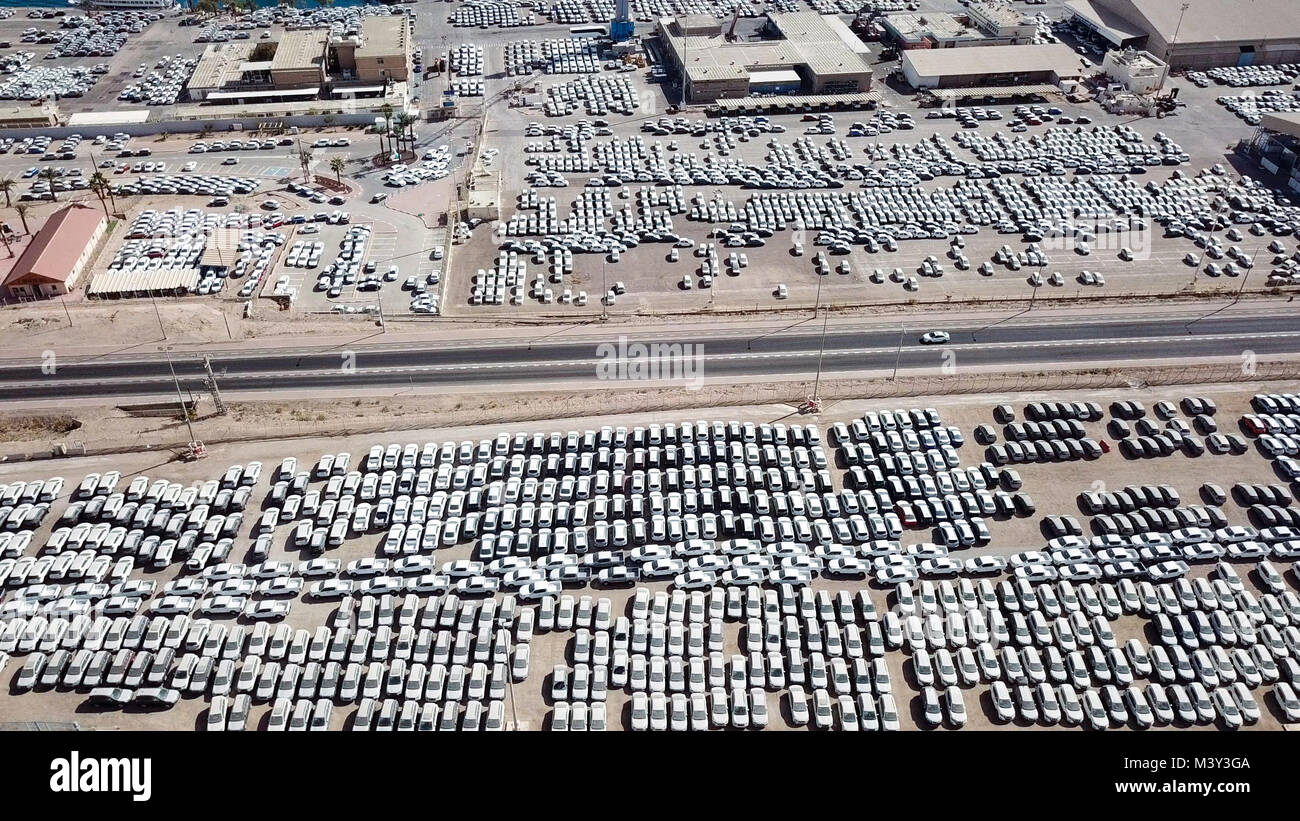 New cars covered in protective white sheets parked in a holding ...