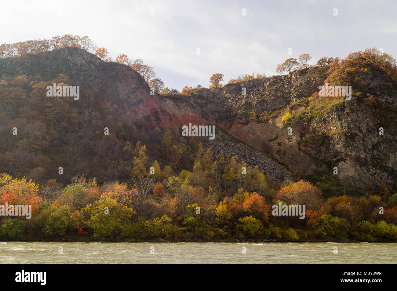 Autumn scene of a rock on the river bank Stock Photo - Alamy