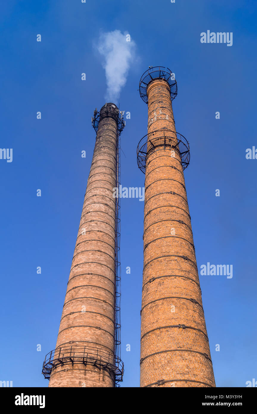 Industrial brick pipes smoke. white smoke on a background of blue sky ...