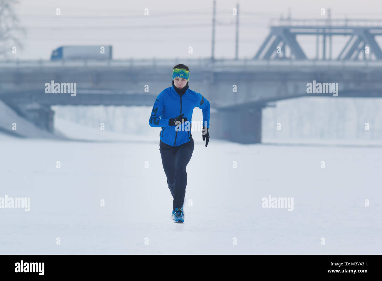 Young male athlete running in winter through the snow Stock Photo - Alamy