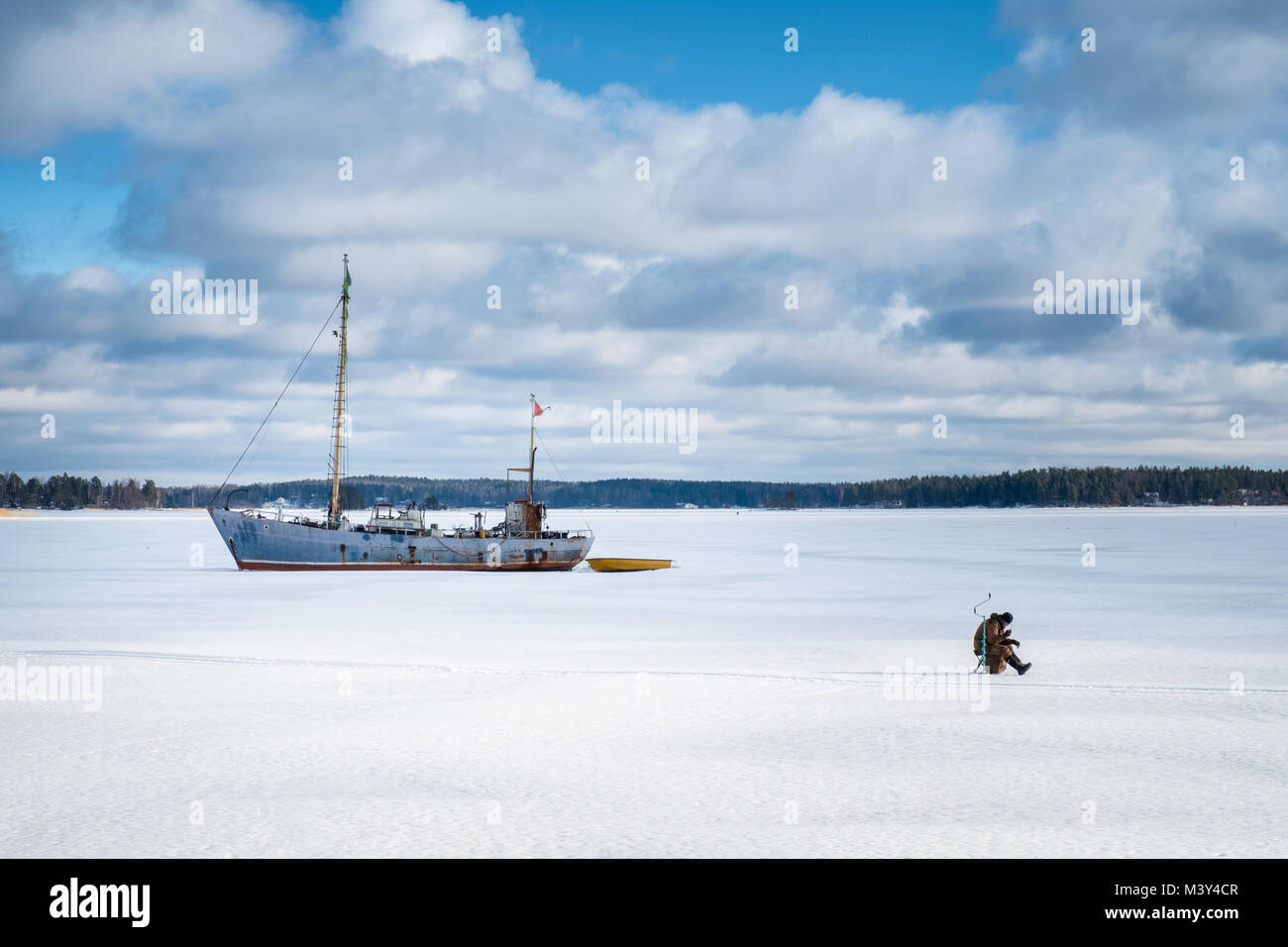 Porvoo, Finland - February 24, 2017: Fisherman sitting and ice fishing ...
