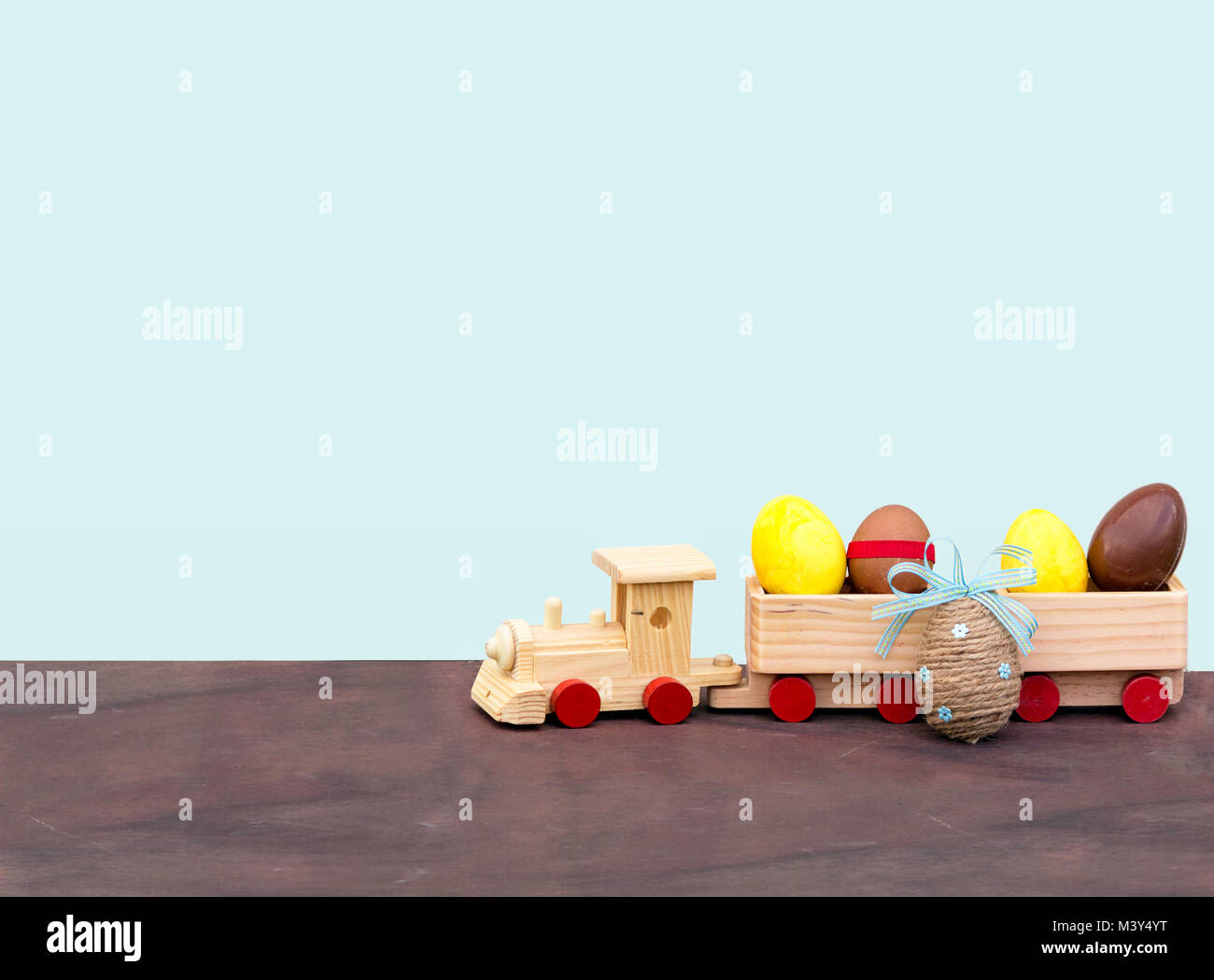 A little wood train with red wheels bringing colorful easter eggs for ...