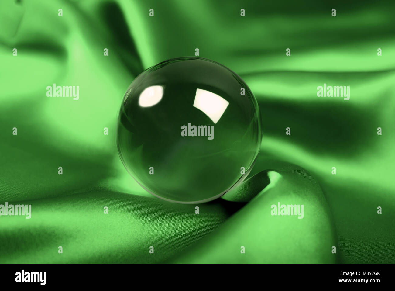 glowing crystal ball on green background Stock Photo - Alamy