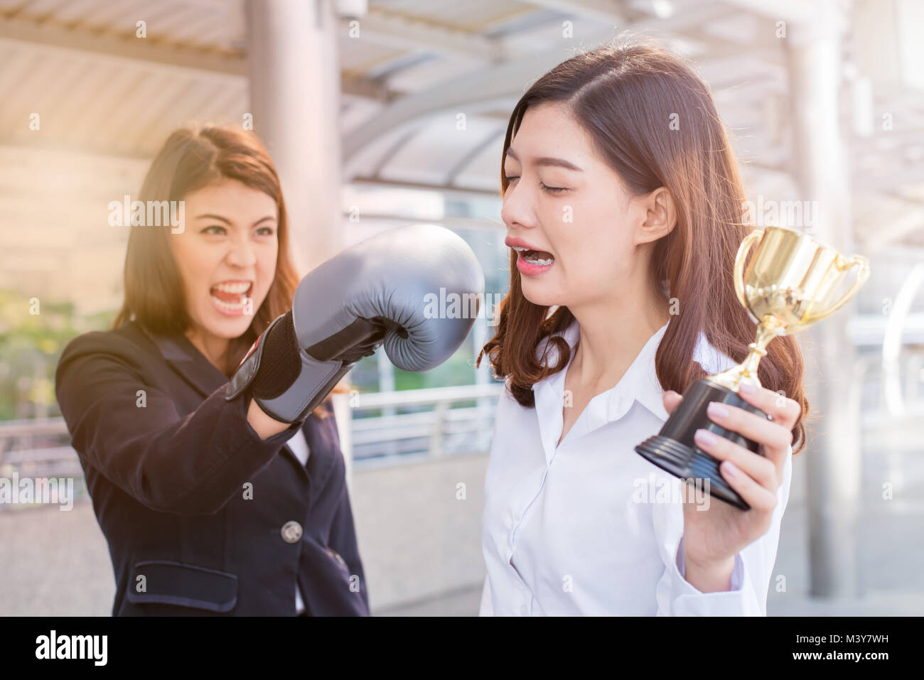 Fight her friend to win trophy, Business competition Stock Photo - Alamy