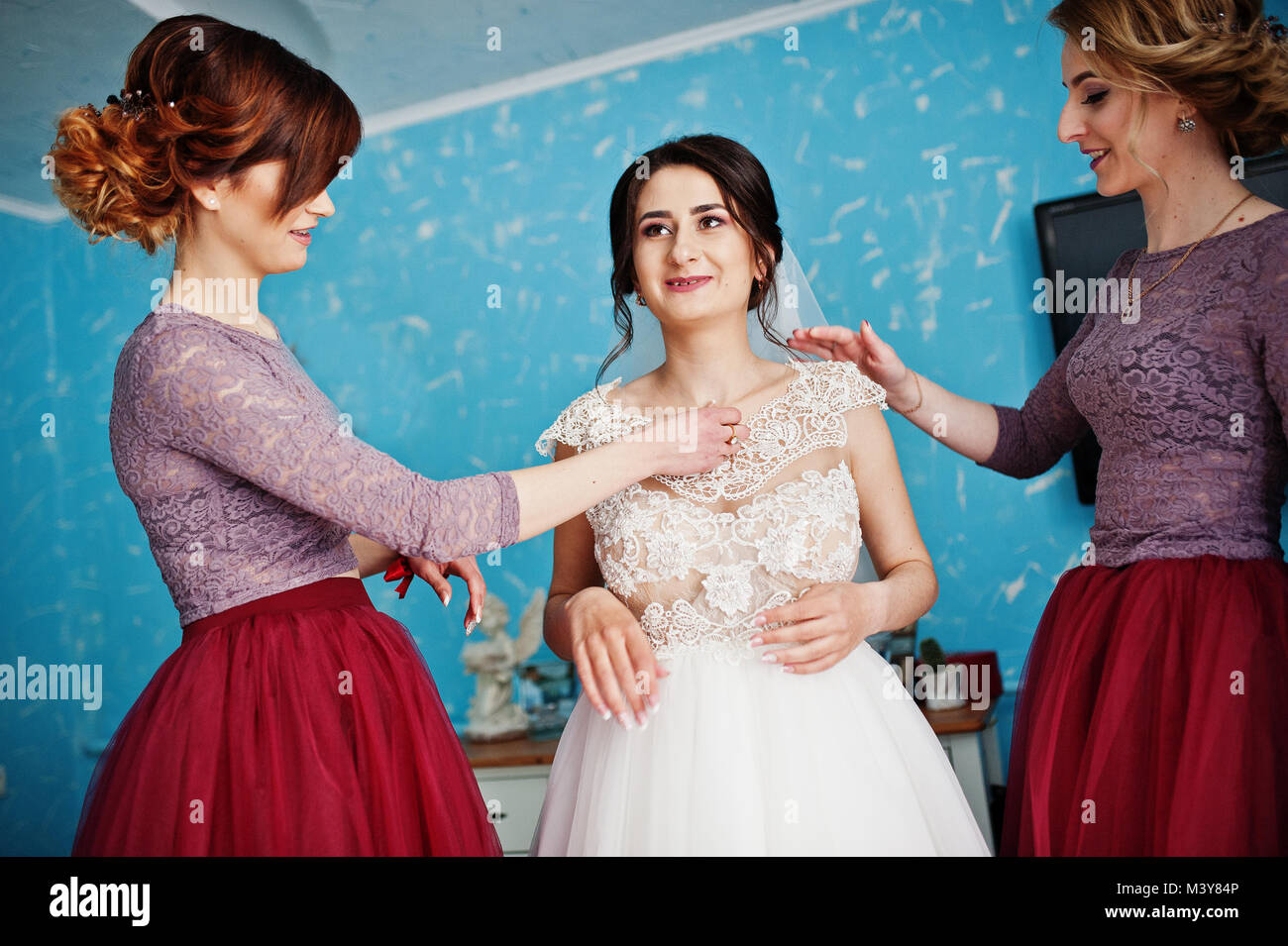 Bridesmaids helping bride to get ready for her wedding ceremony Stock ...