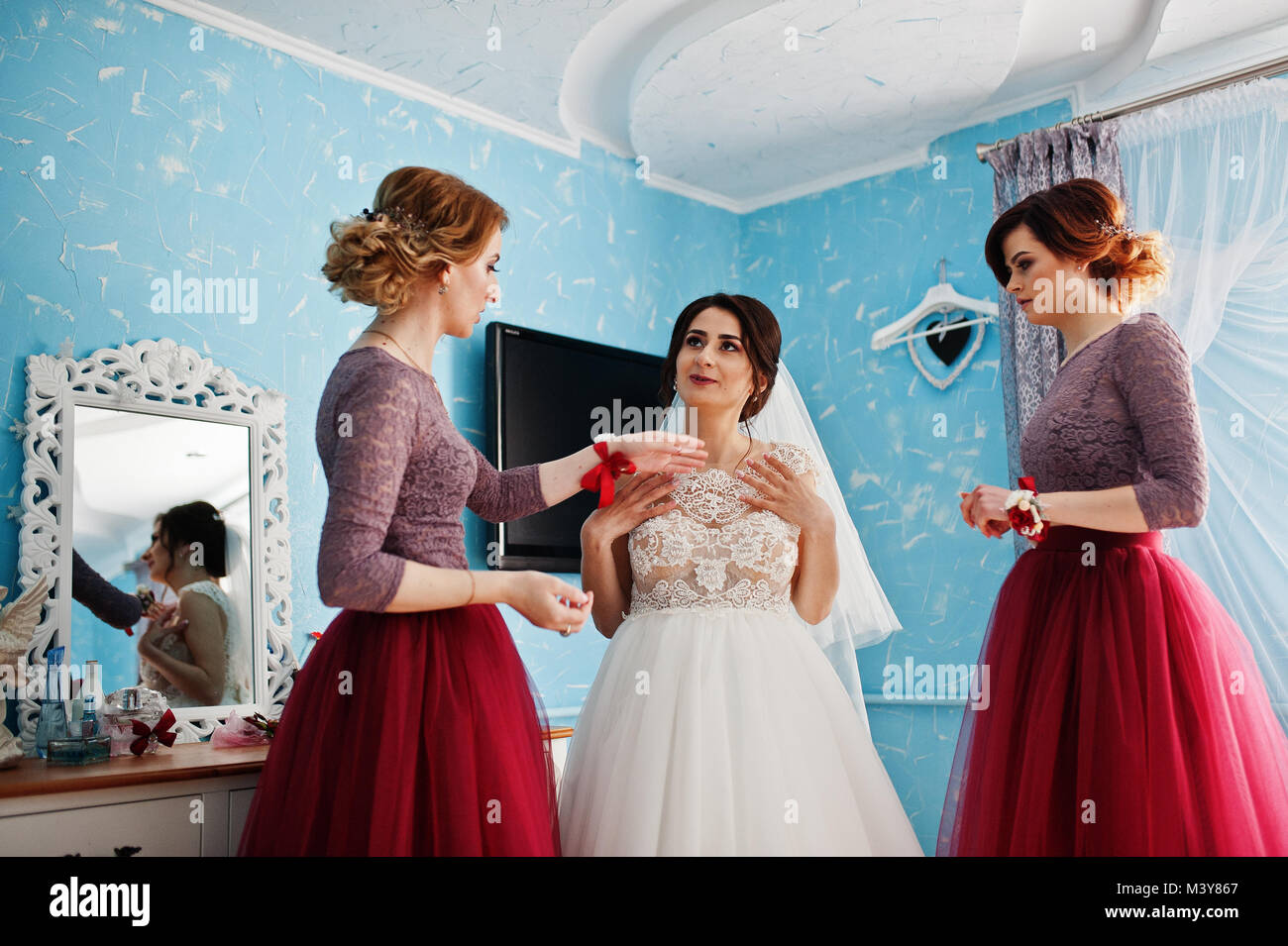 Bridesmaids helping bride to get ready for her wedding ceremony Stock ...