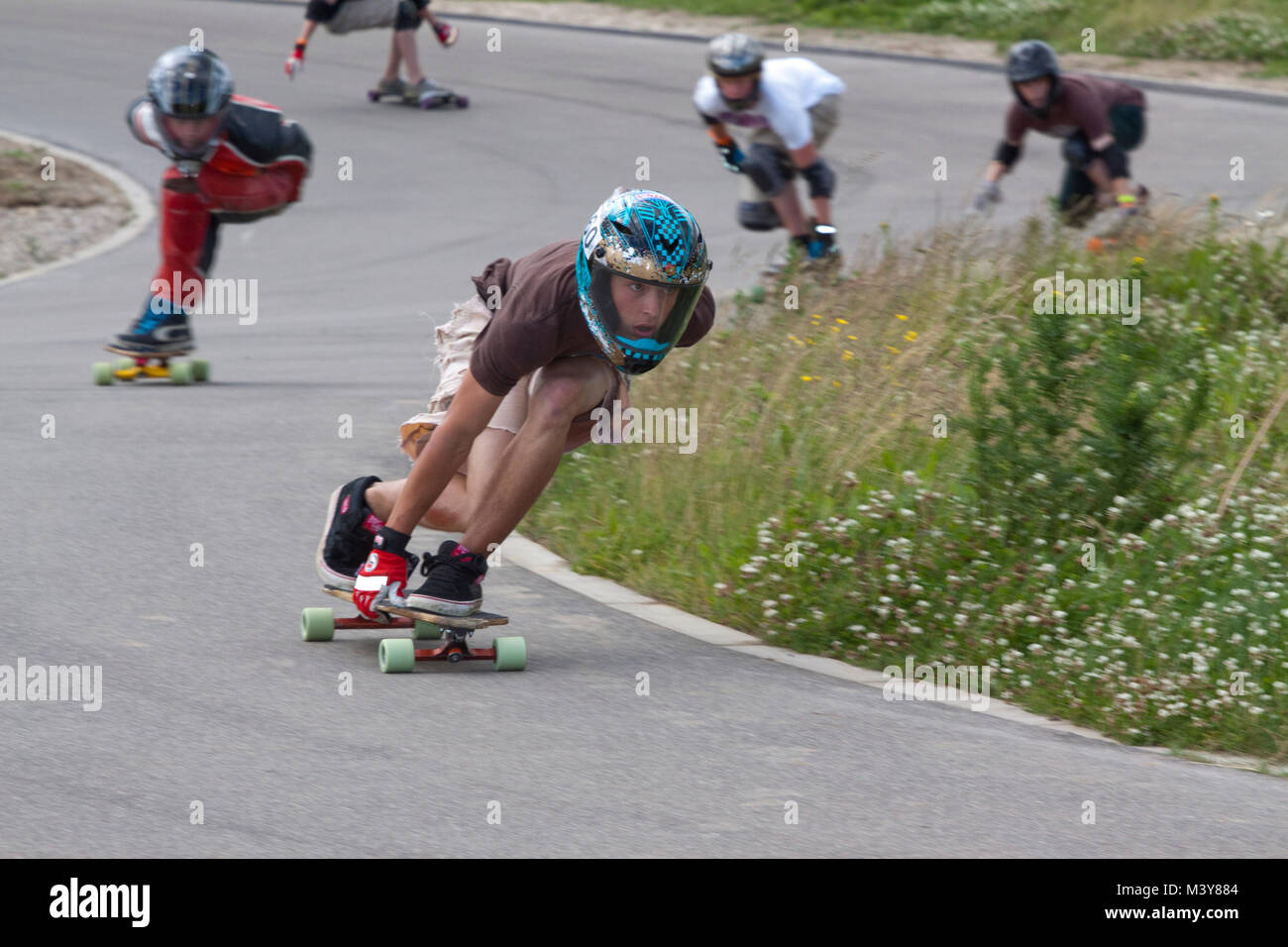 Downhill skateboarders sweep through an S bend Stock Photo - Alamy