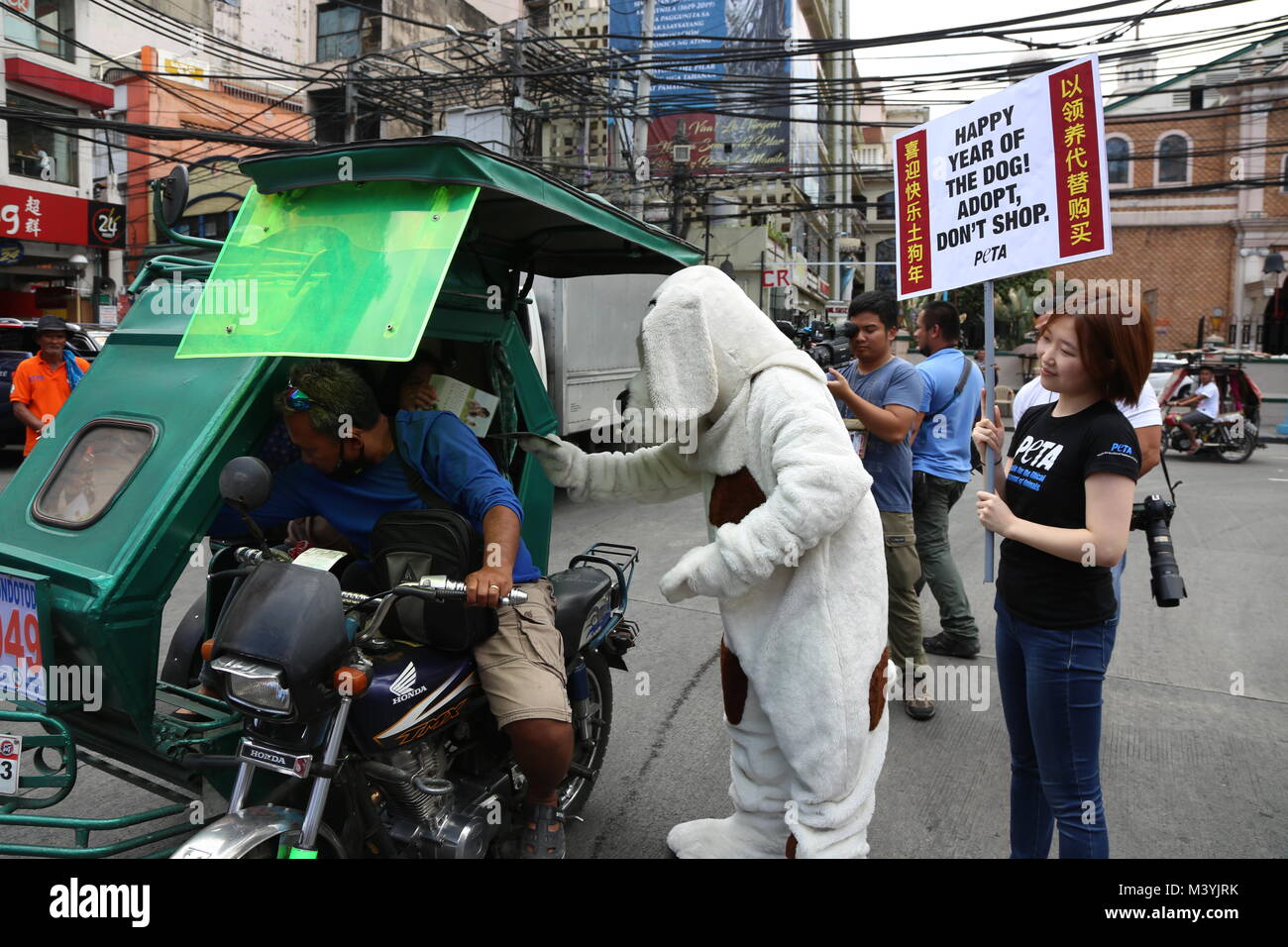 Manila. 12th Feb, 2018. A six-foot-tall dog mascot distributes leaflets ...