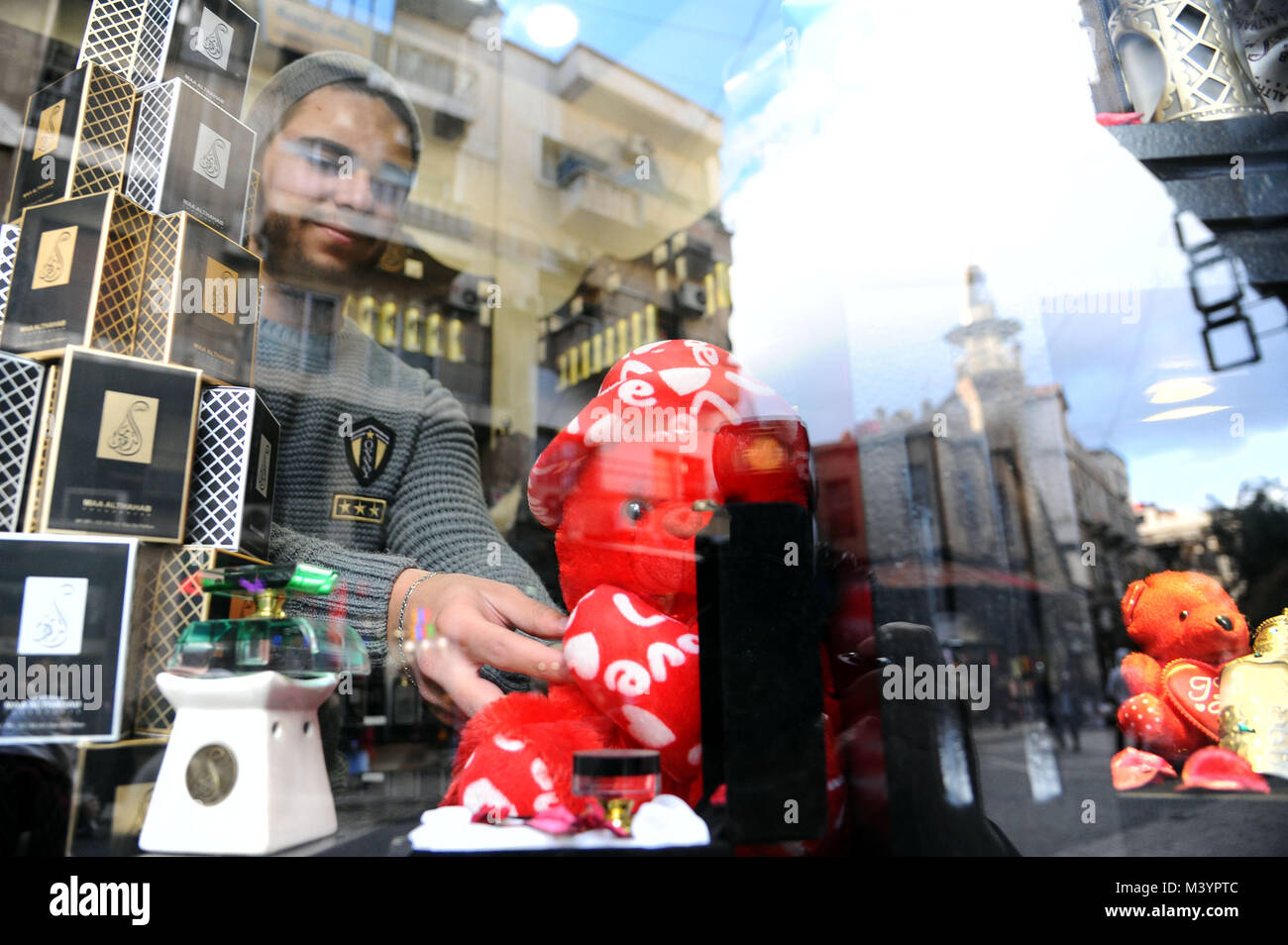 Damascus, Syria. 13th Feb, 2018. A shop owner places a red teddy bear ...