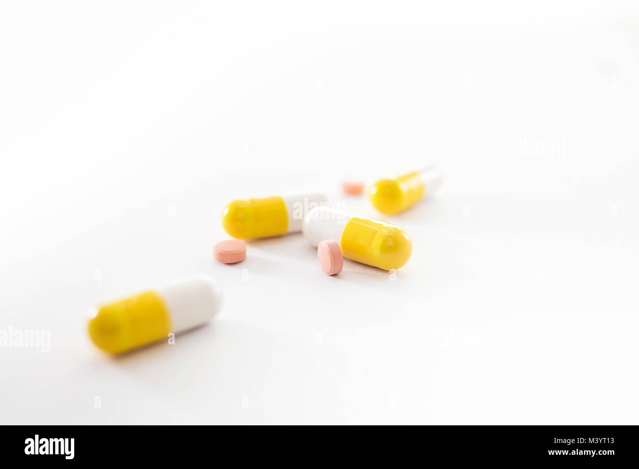 Yellow pills ant red tablets isolated on white with copy space ...