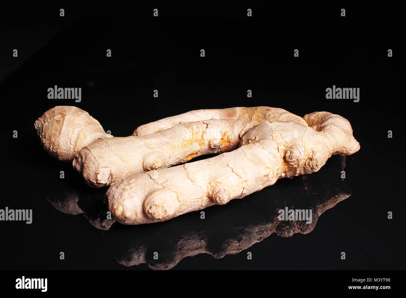 Ginger. Whole ginger on black reflective studio background. Isolated ...
