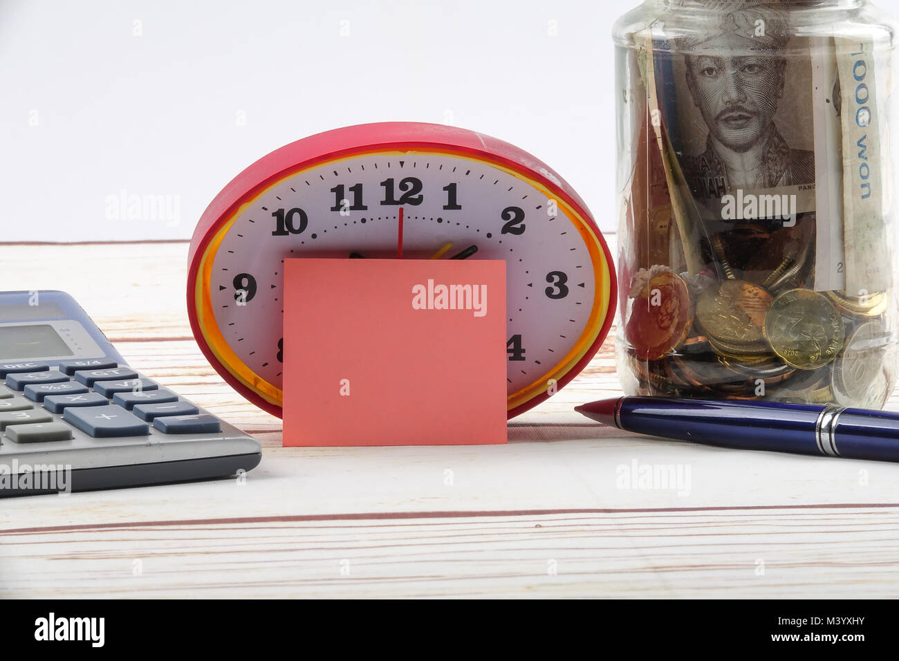 TAX DAY CONCEPT; Clock,red note,calculator and coins in the mason jar ...