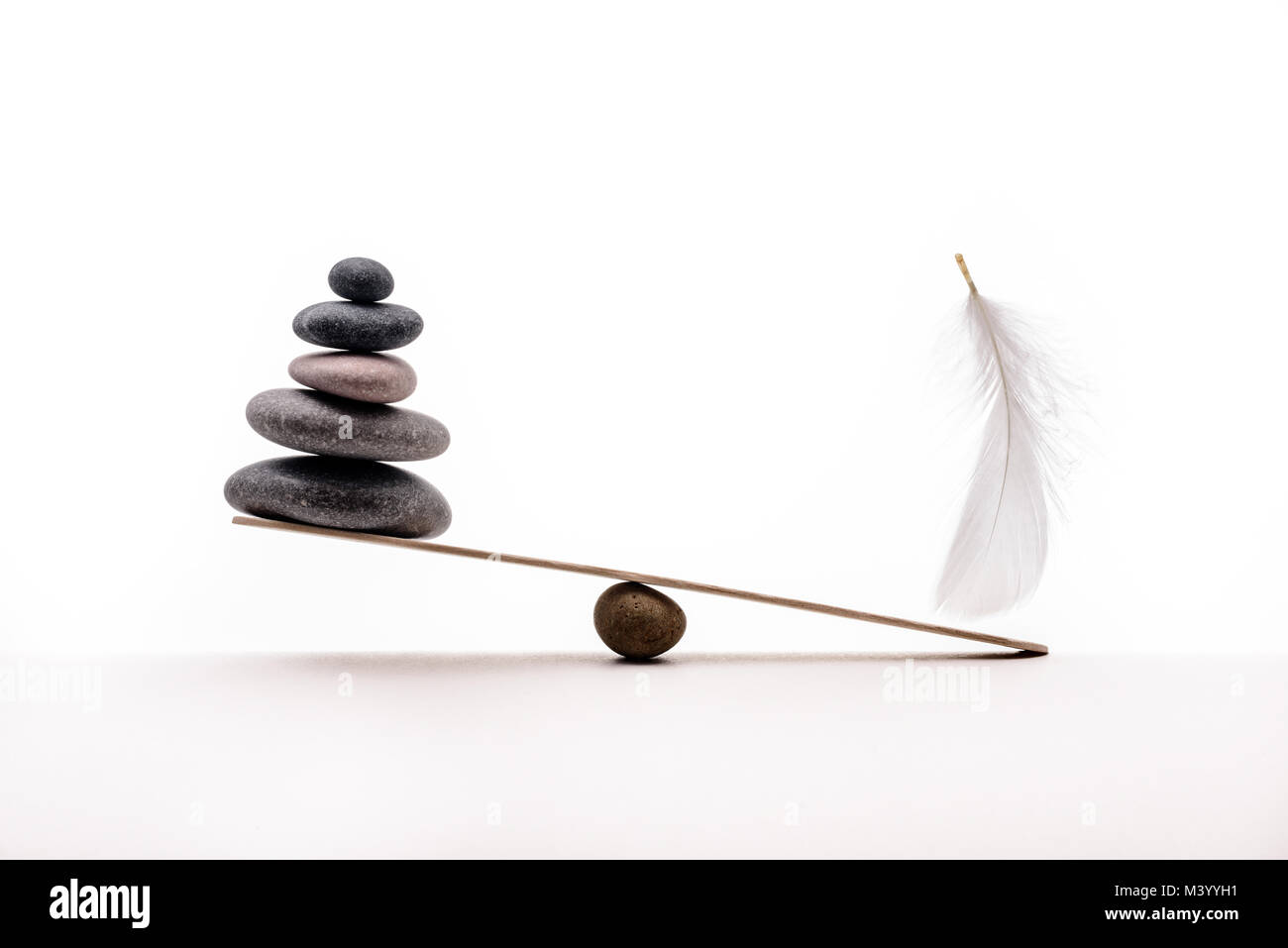 Stone balance with plume. Concept of heavy and light Stock Photo - Alamy