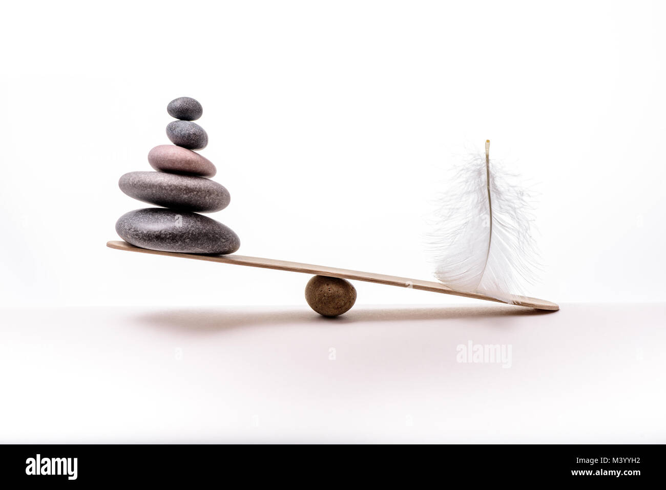 Stone balance with plume. Concept of heavy and light Stock Photo - Alamy