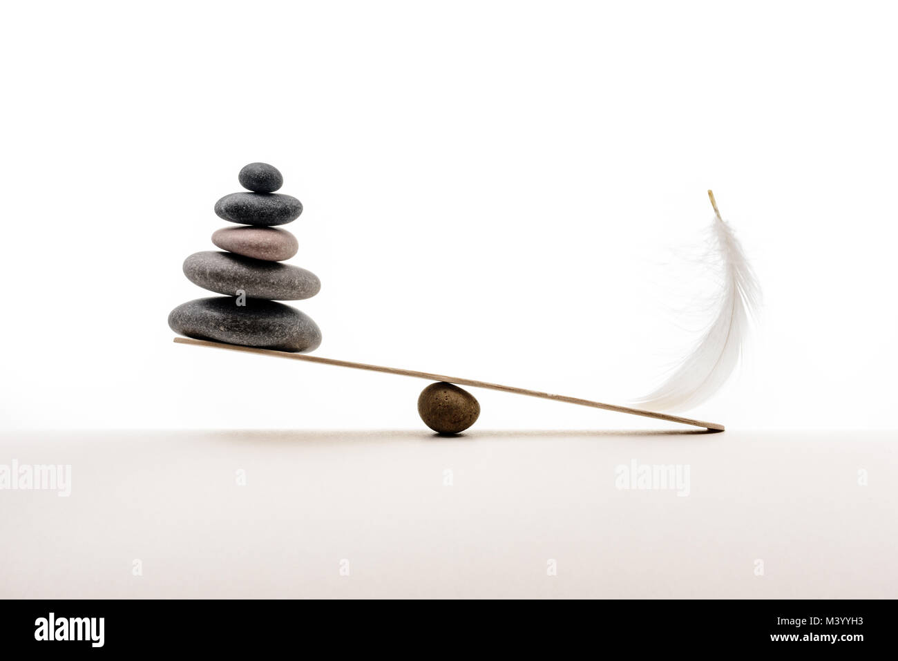 Stone balance with plume. Concept of heavy and light Stock Photo - Alamy