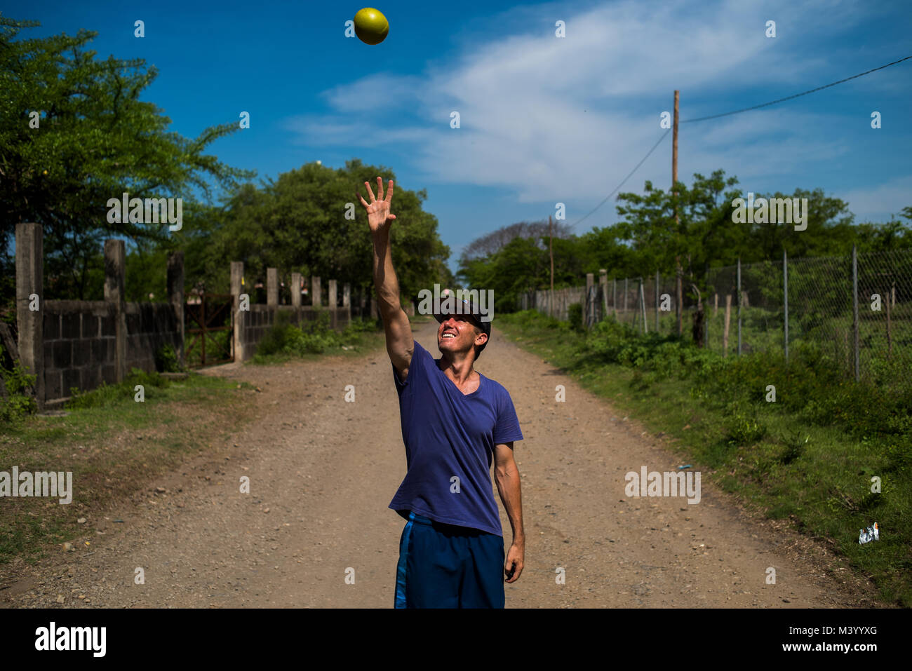 A man throws a fruit in the air Stock Photo - Alamy