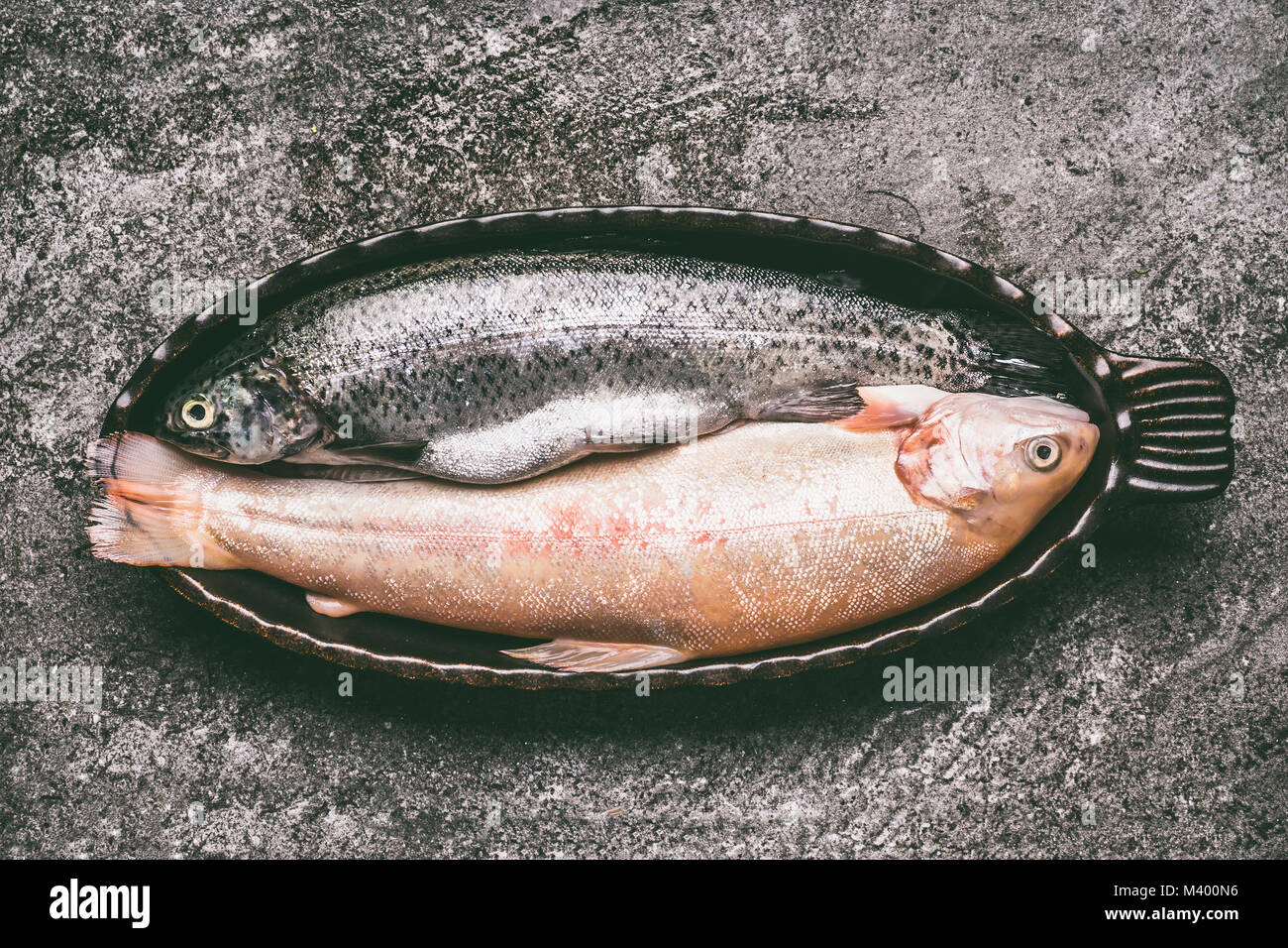 Two varieties of trout: brown trout and rainbow trout in baking bowl on ...