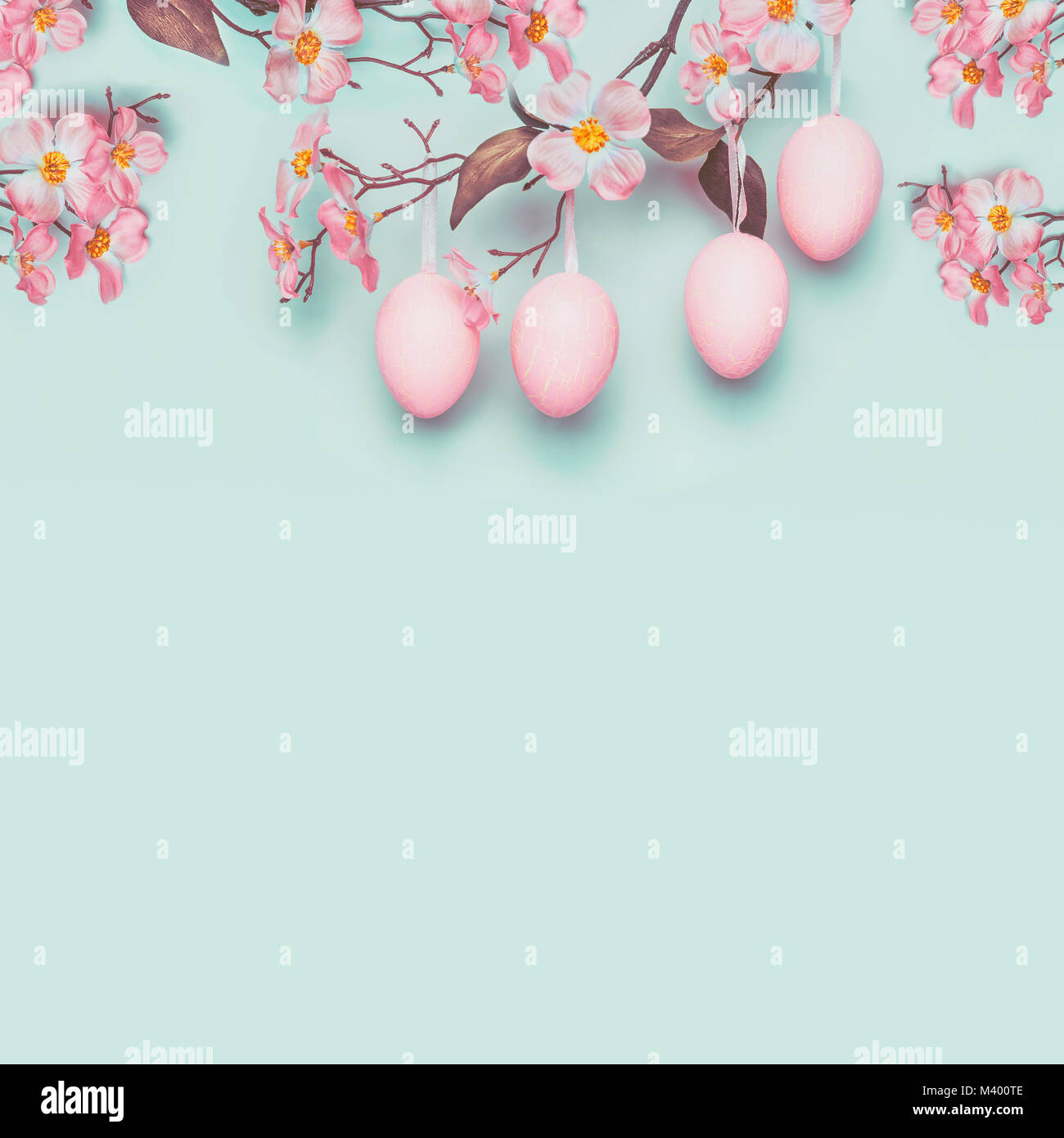 Easter layout with hanging pastel pink eggs and spring blossom at light ...