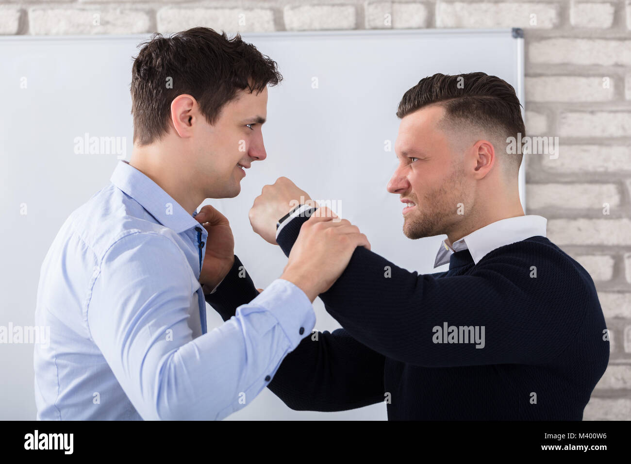 Close-up Of Aggressive Businessman Fighting With His Coworker In Office ...
