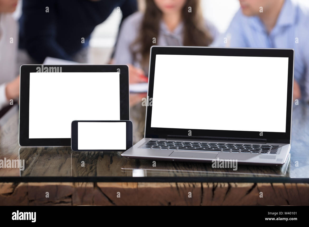 Modern Electronic Devices On Office Desk With Businesspeople At ...