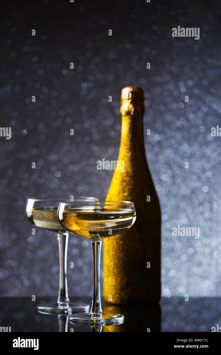 Picture of bottle of sparkling wine in gold wrapper with two wine ...