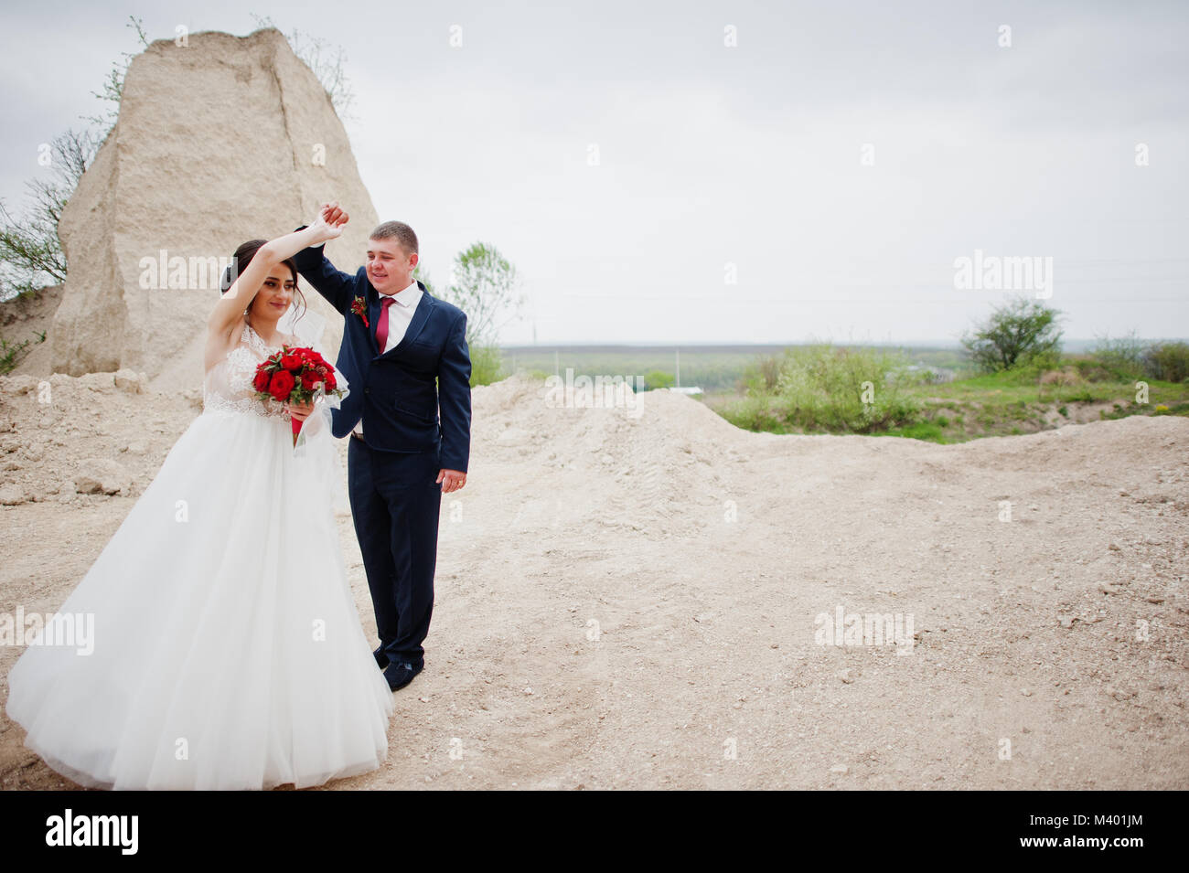 Young wedding couple posing in sand quarry on their wedding day Stock ...