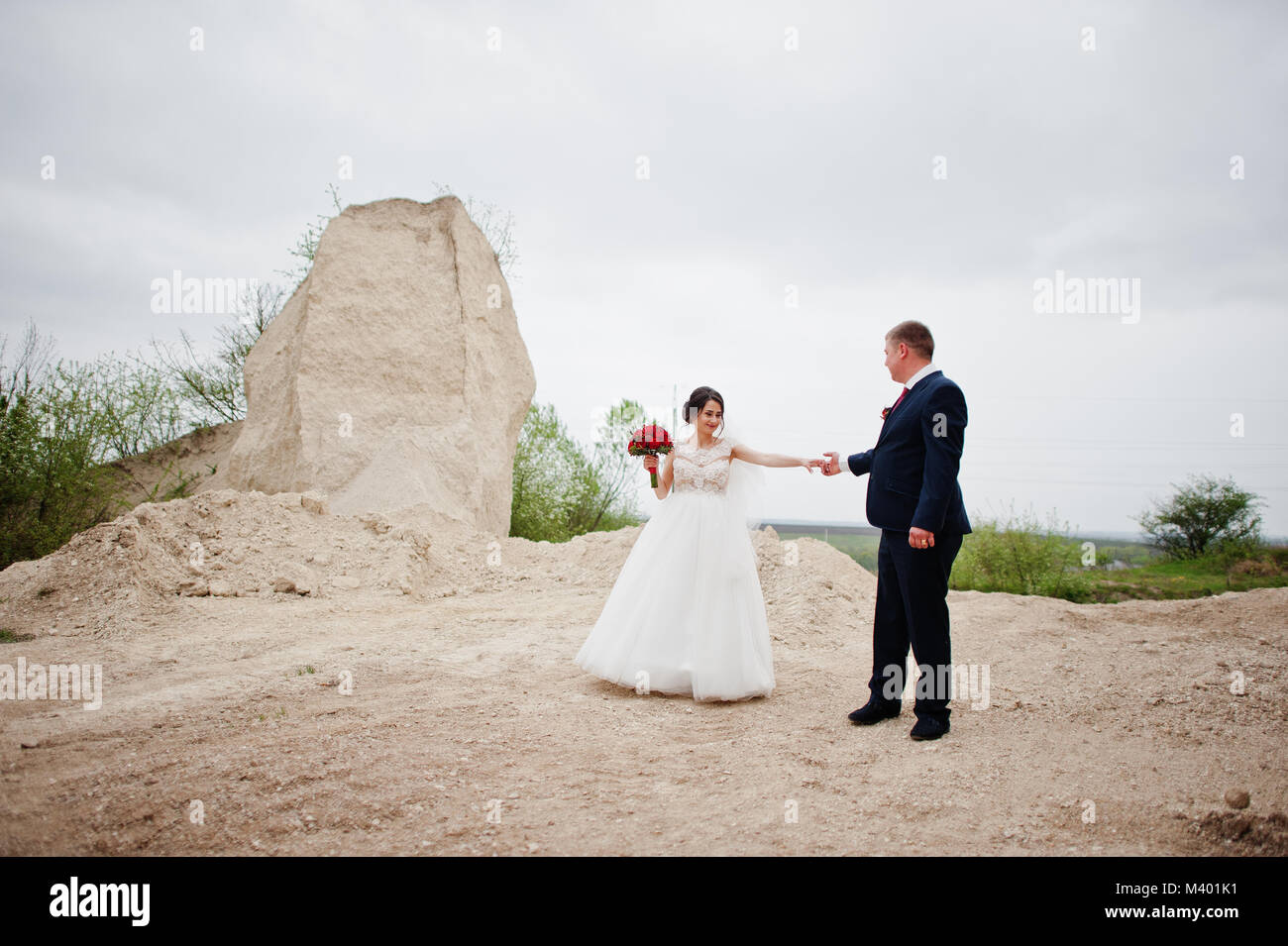 Young wedding couple posing in sand quarry on their wedding day Stock ...