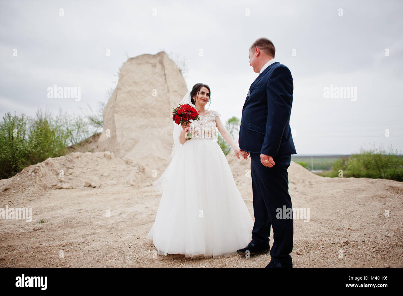 Young wedding couple posing in sand quarry on their wedding day Stock ...