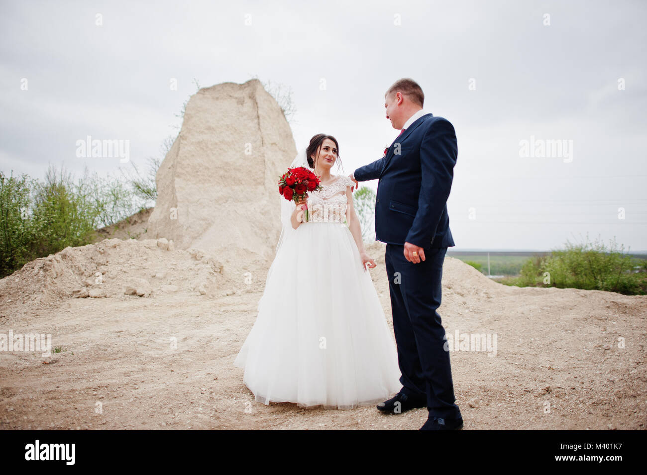 Young wedding couple posing in sand quarry on their wedding day Stock ...