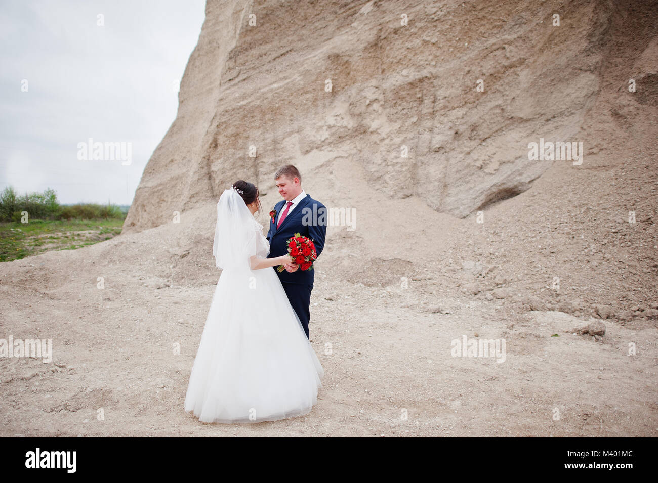 Young wedding couple posing in sand quarry on their wedding day Stock ...