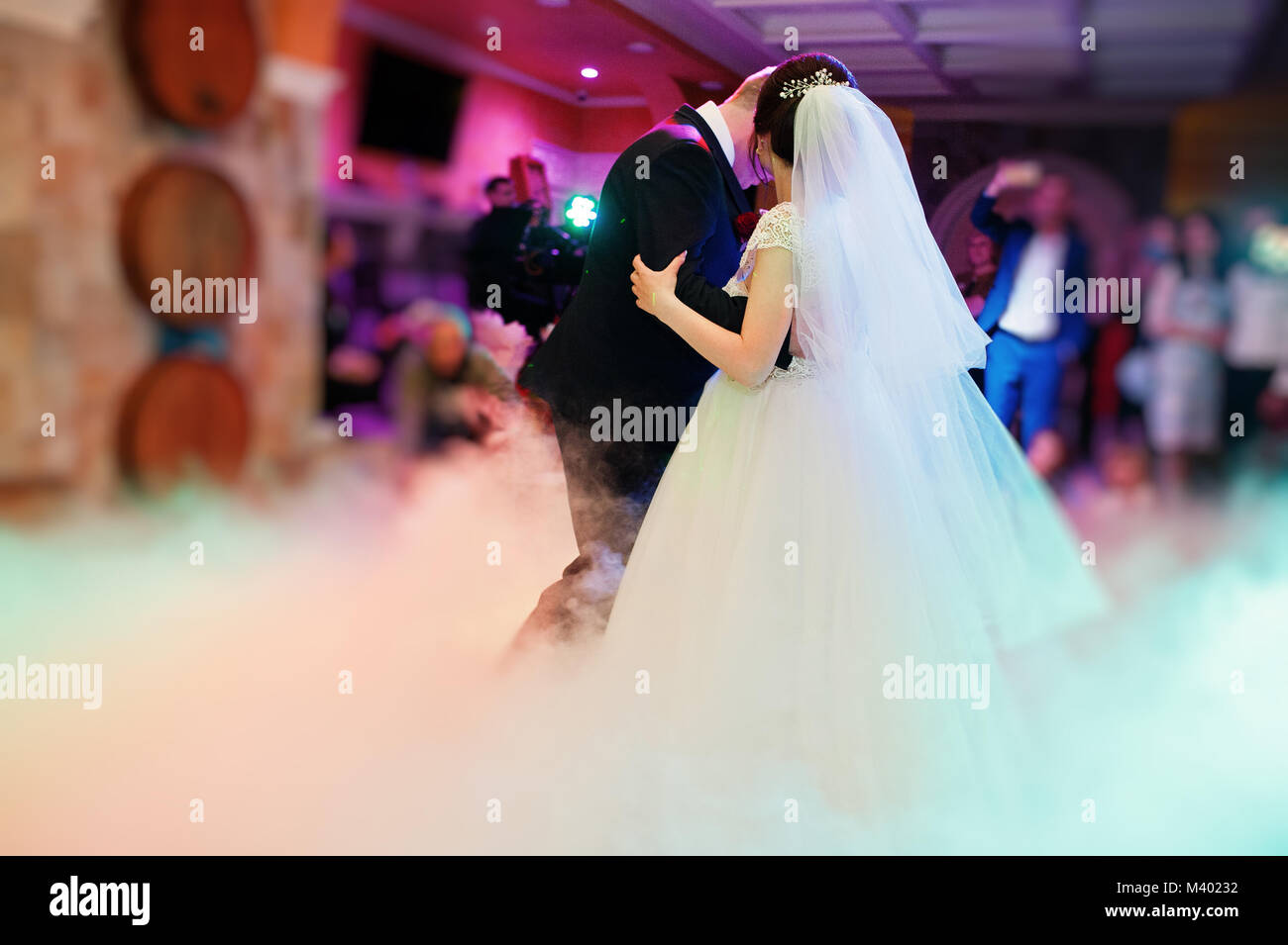 Happy young wedding couple dancing their first dance with different ...
