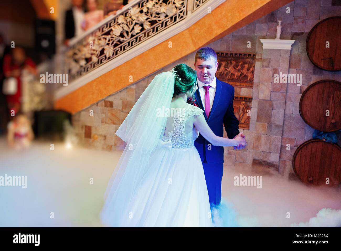 Happy young wedding couple dancing their first dance with different ...